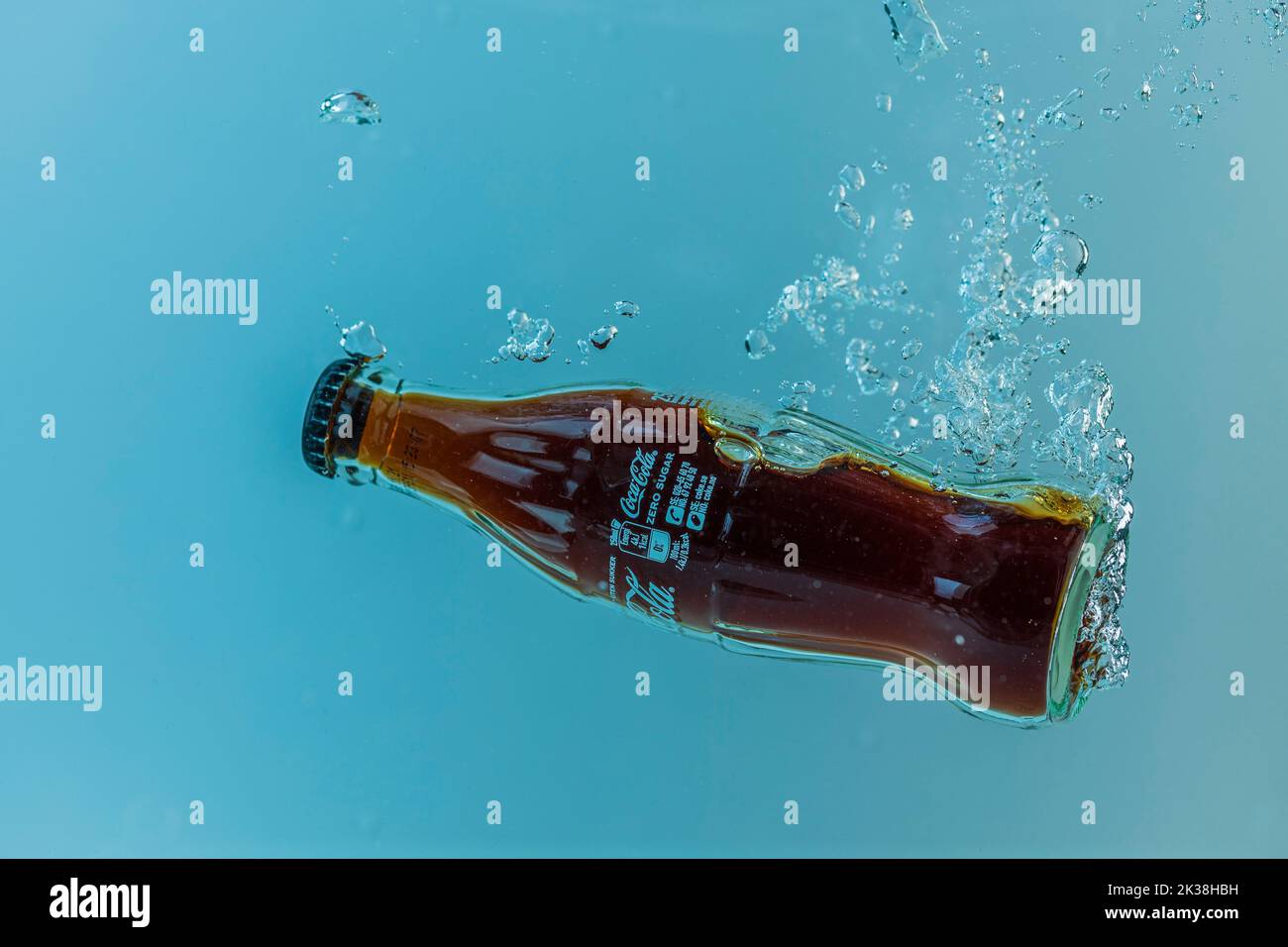 Close up view of drink Coca Cola bottle falling into water isolated on ...
