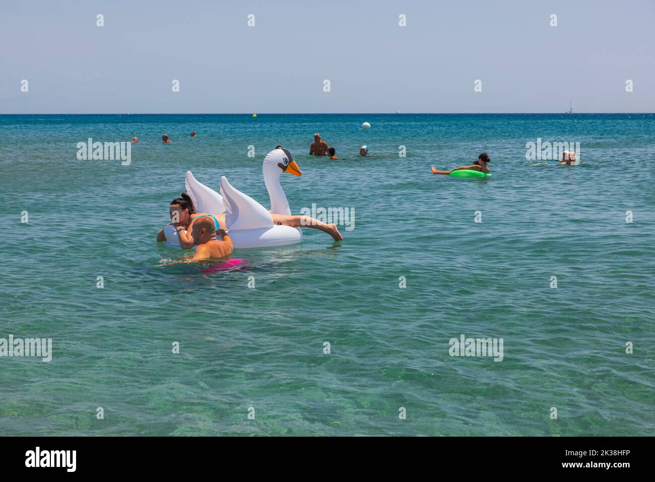 Beautiful view of people swimming in sea. Couple on inflatable white ...