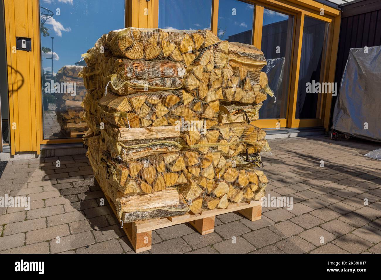 Beautiful view of birch firewood in transport nets on pallet in front ...
