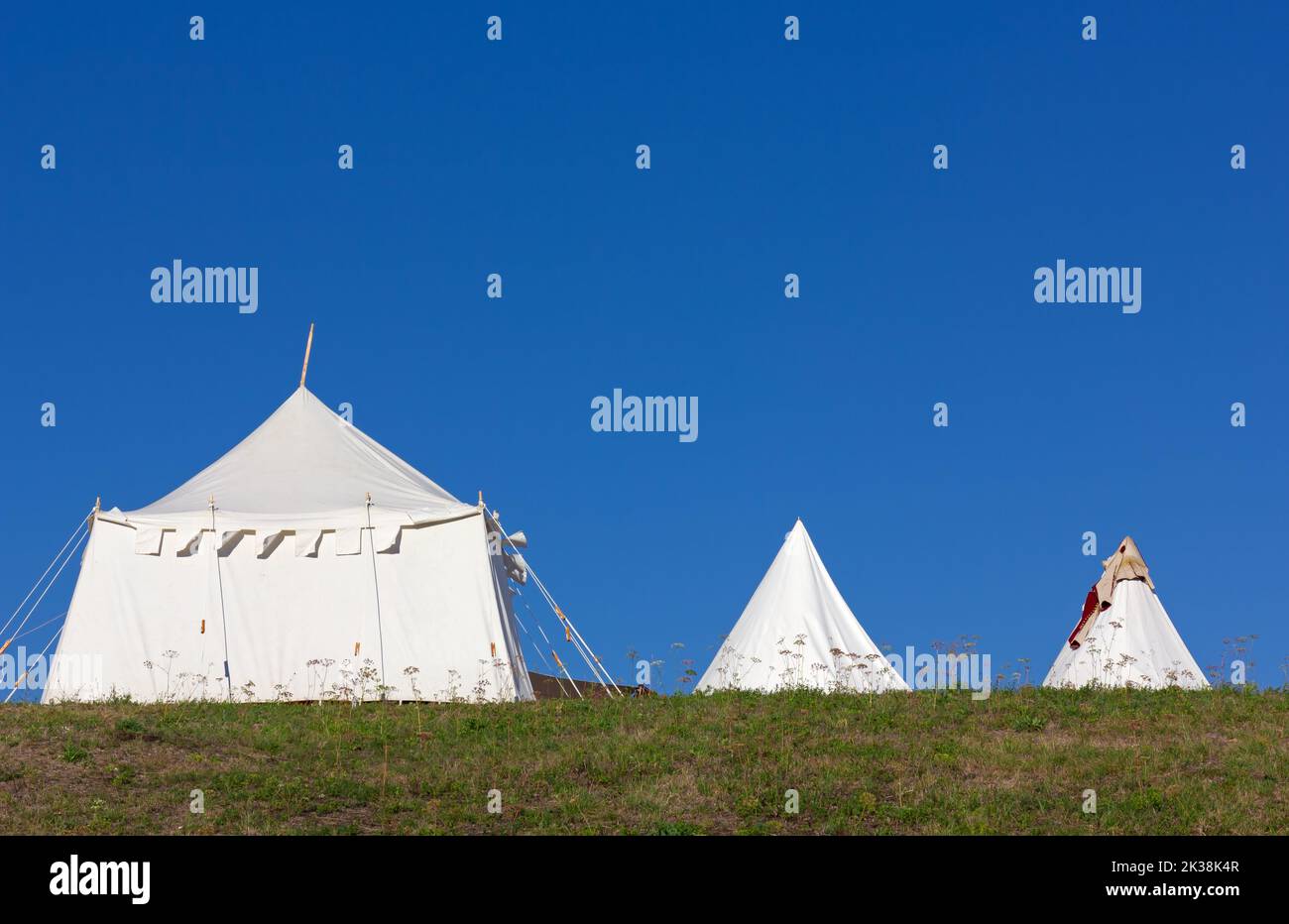 Three tents against a blue sky in an encampment at a historical ...