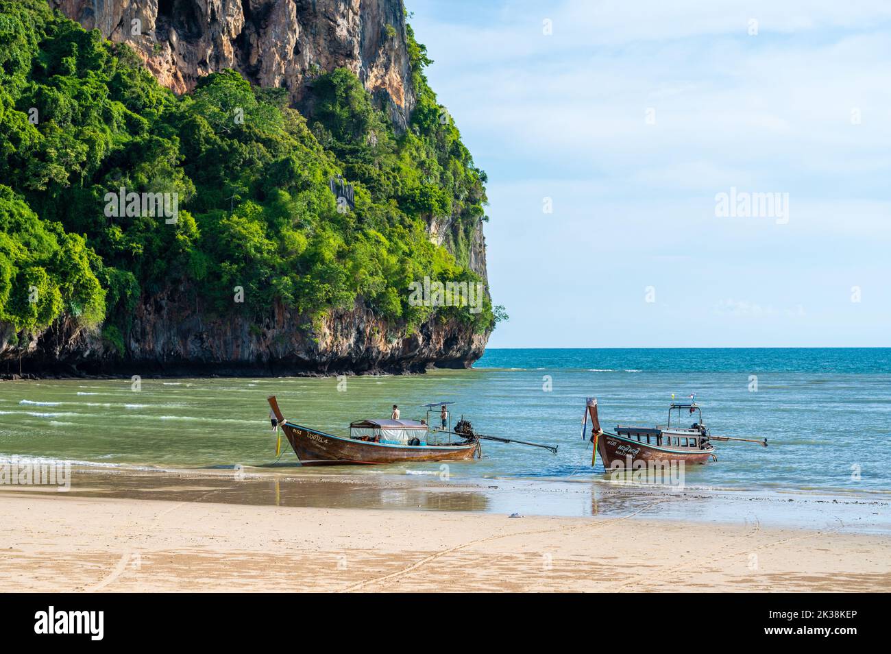 Skiff boats on the blue water of the ocean surrounded by cliffs Stock ...