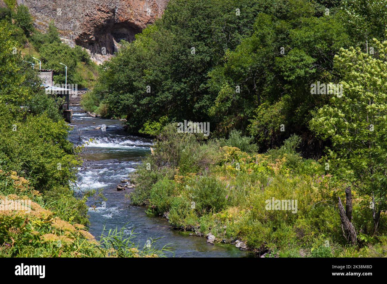 An aerial view of flowing river surrounded by rocks and trees Stock ...