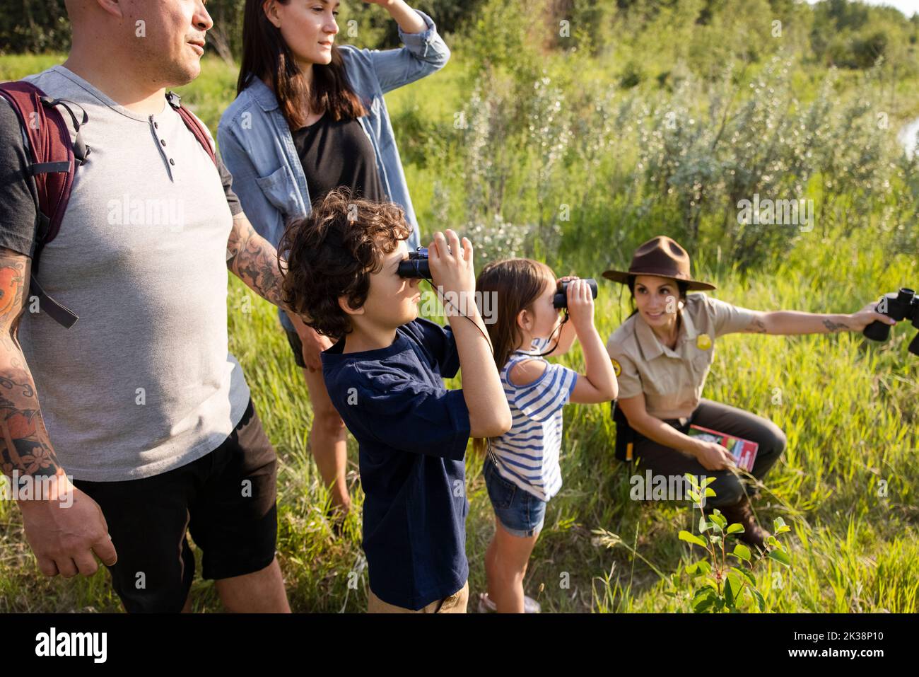 Ranger showing children wildlife with binoculars Stock Photo - Alamy