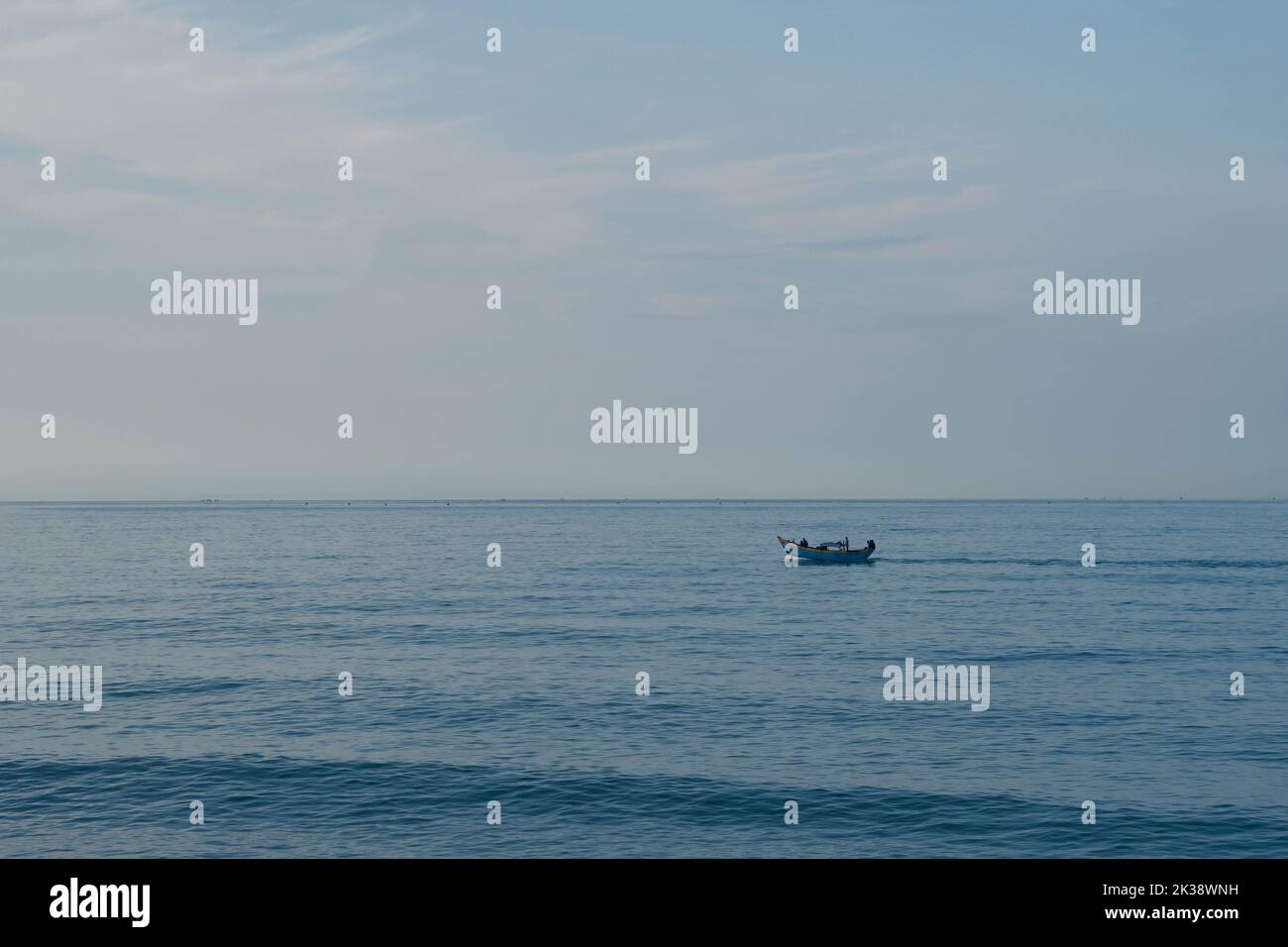 Simple background Calm dark blue sea fishing boat alone white pale ...