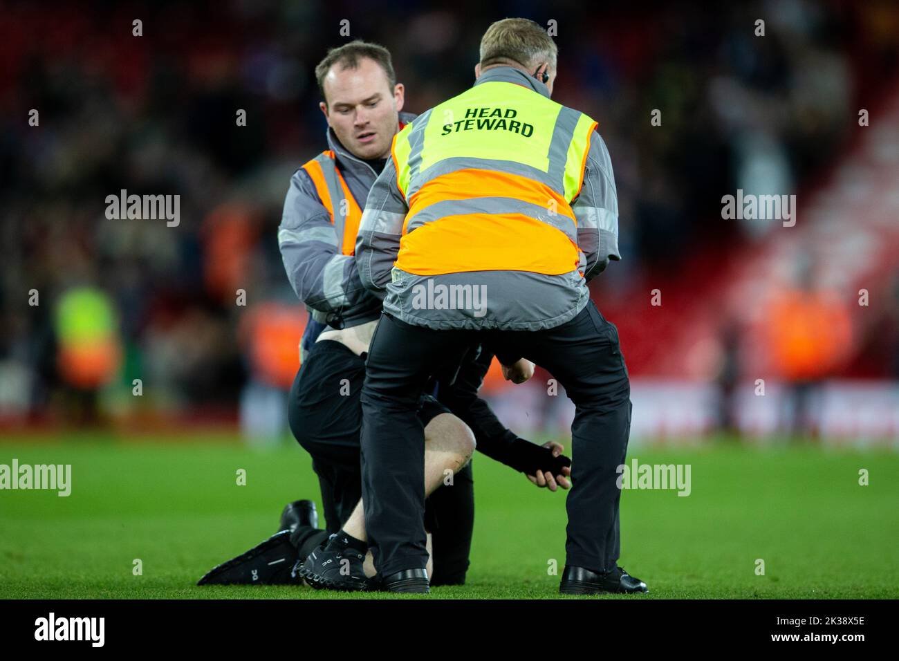 Liverpool stewards wrestle a pitch invader to the ground during the The ...