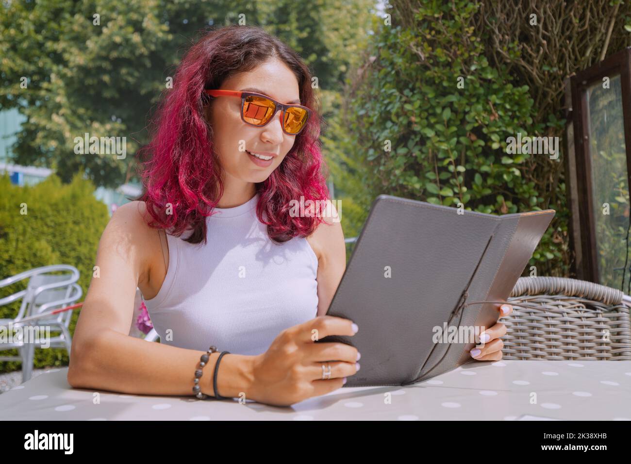 Woman reading menu and choosing dinner food and beverage in outdoor ...