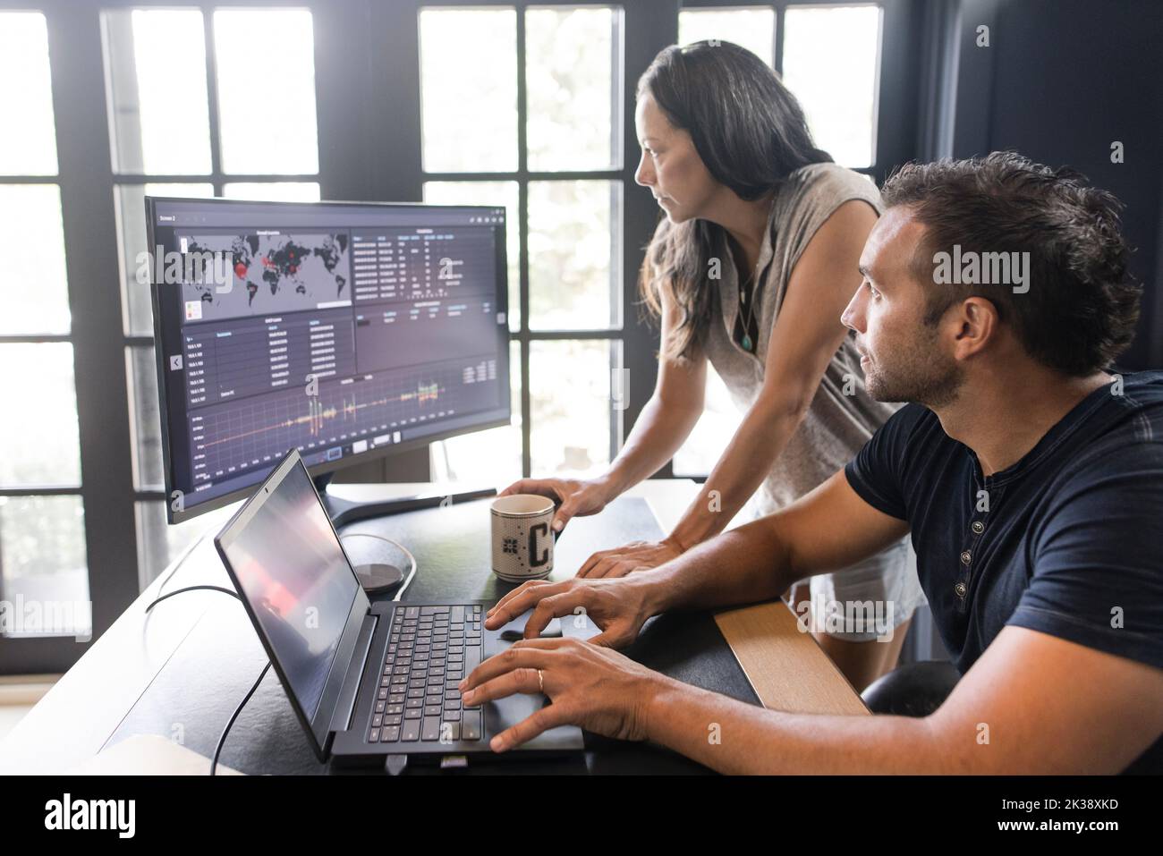 Couple working at computer and laptop in home office Stock Photo - Alamy