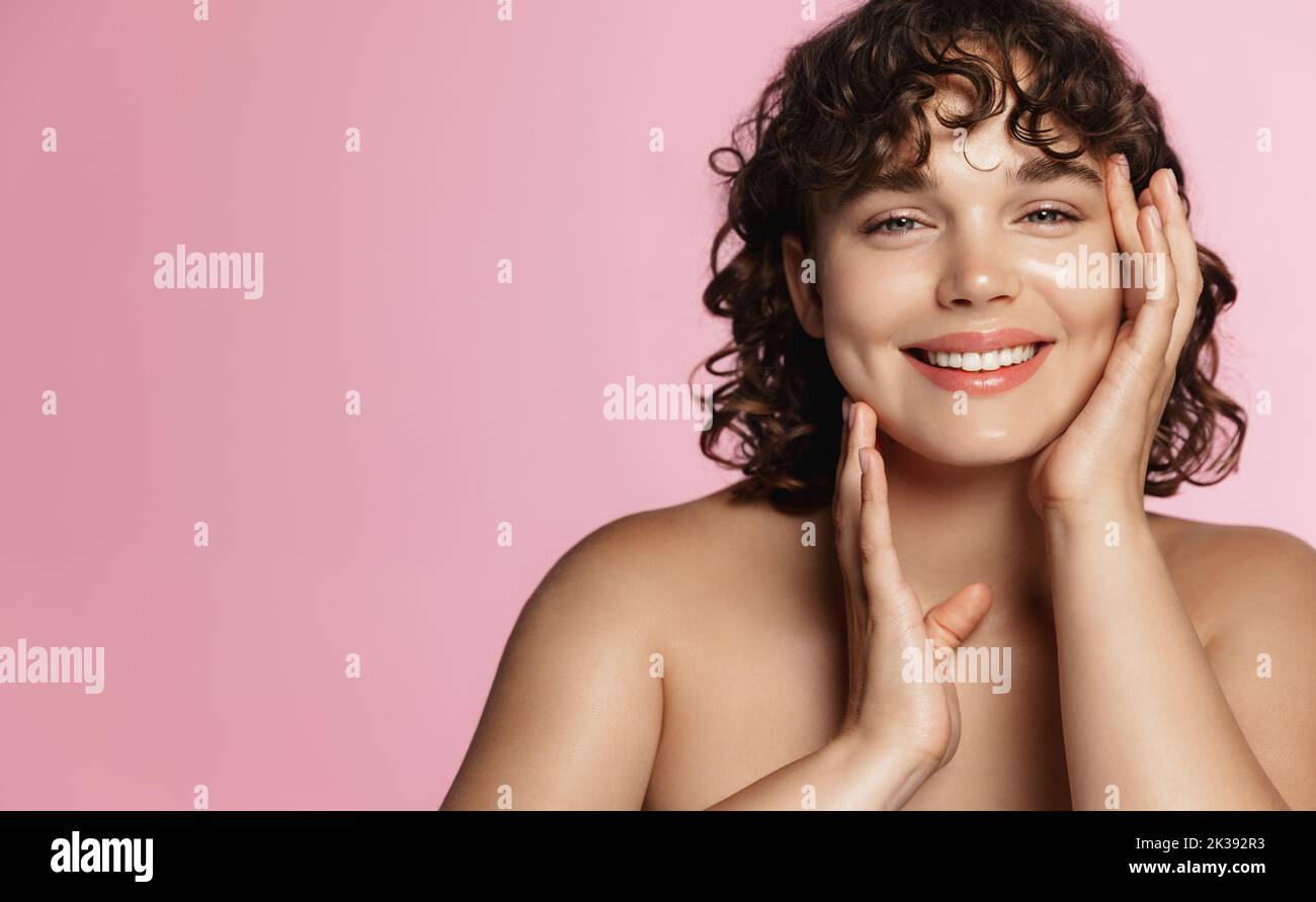 Beautiful natural girl smiling, rubbing her face with facial cleanser ...