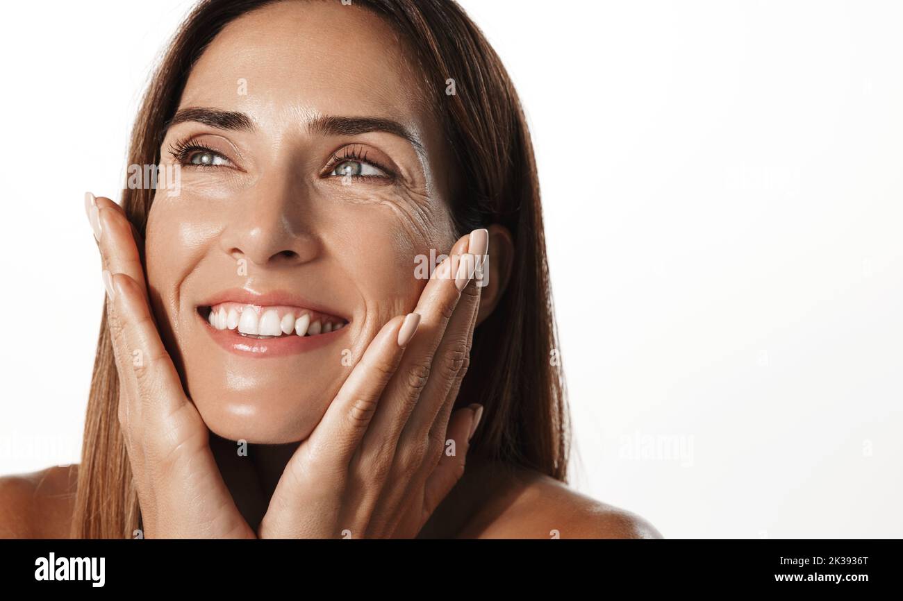 Close up portrait of happy middle-aged woman face, splash of smth on her face. Female model 40 ...