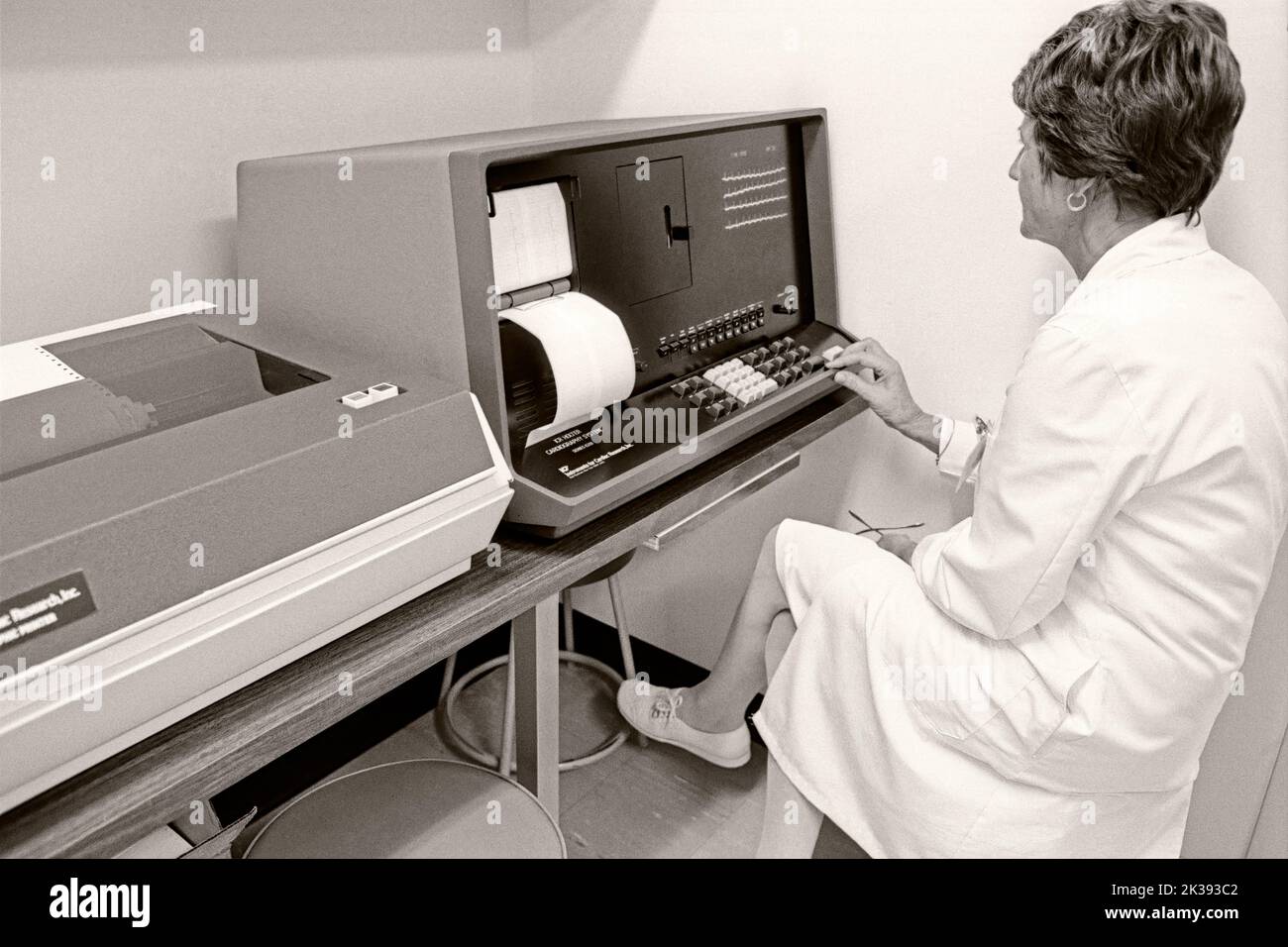 Medical technician working at a vintage electrocardiogram monitor ...