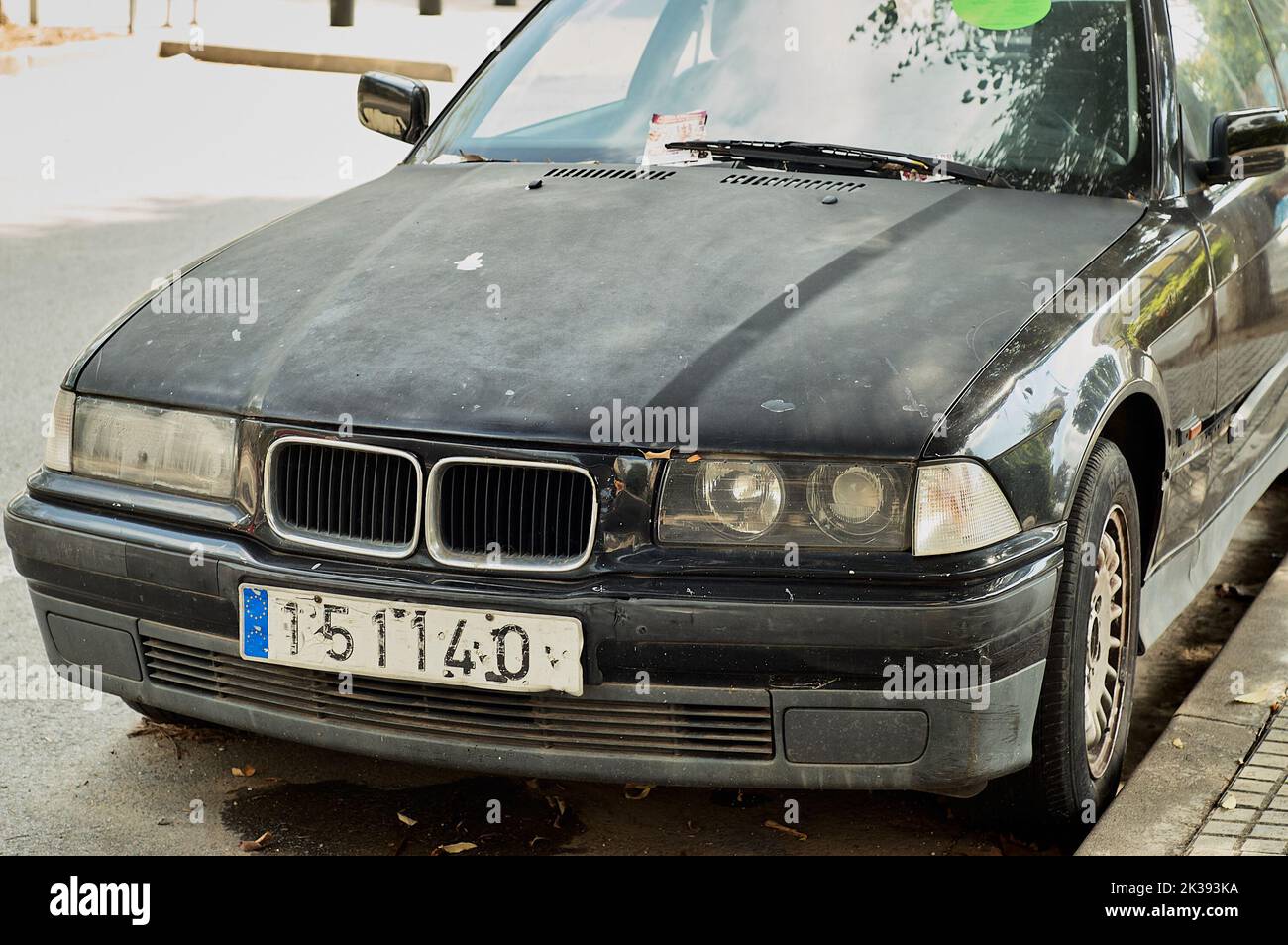 High-end car in very bad condition abandoned on the street and with a ...