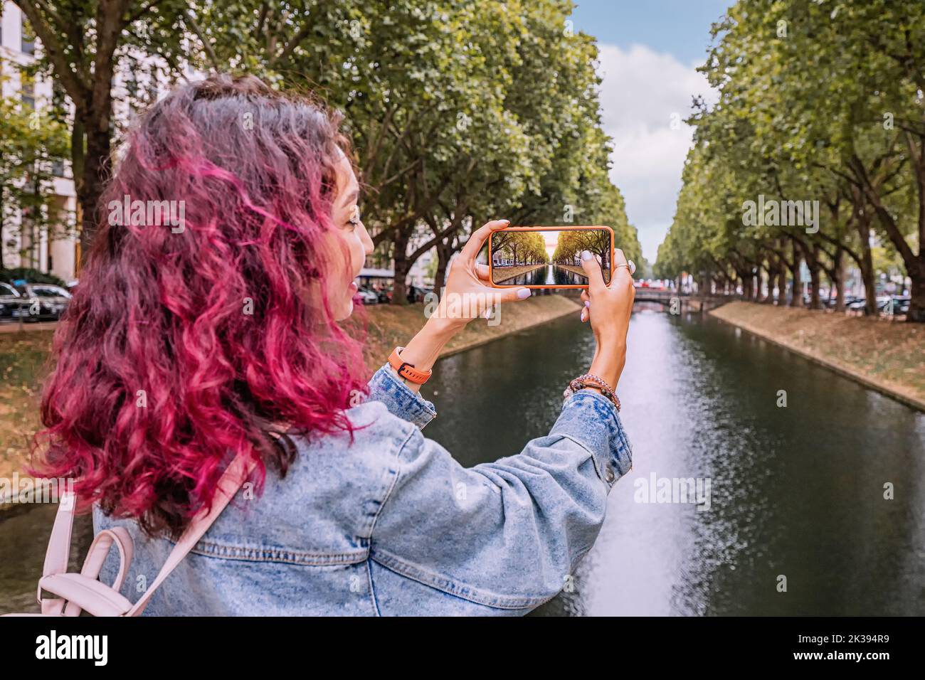 Happy girl travel blogger takes photos on her smartphone of the famous ...