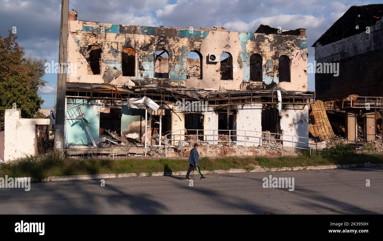 A woman walks past destroyed buildings in Izium, Ukraine. Residents of ...