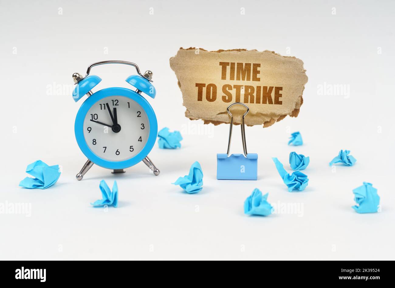 Time concept. On a white surface, an alarm clock, an office clip ...