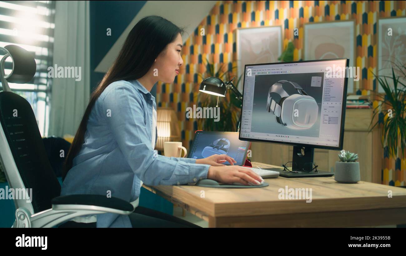 Asian female freelancer working from home office and creating 3D prototype of modern VR headset ...