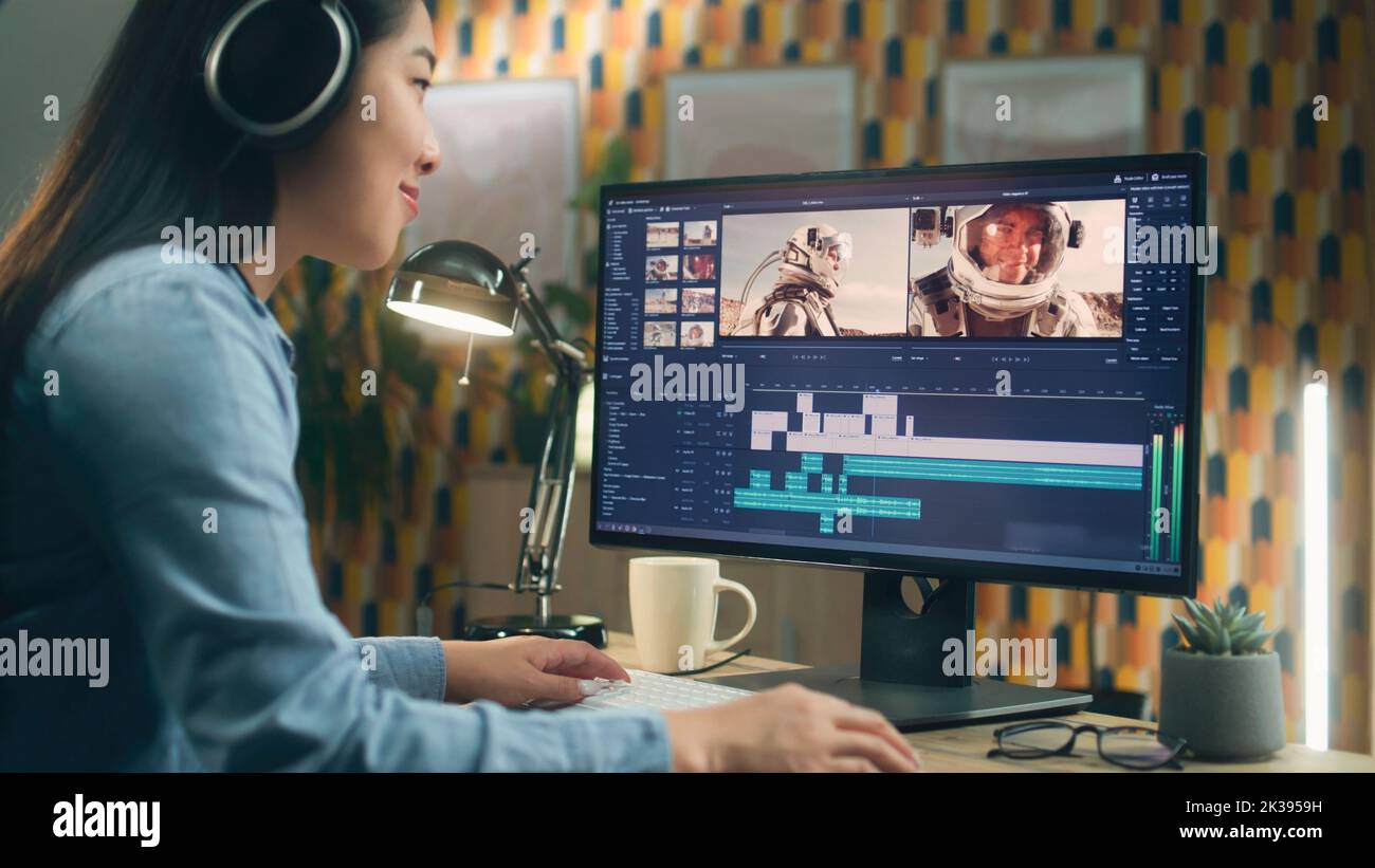 Asian woman in headphones working remotely on pc from home office and editing video with ...