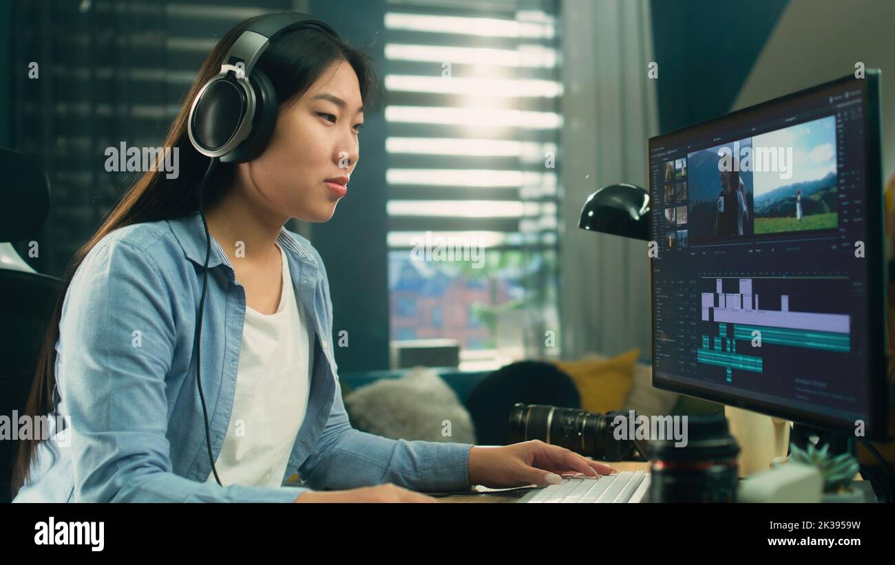 Female asian freelancer editing video for customer or travel blogger in ...
