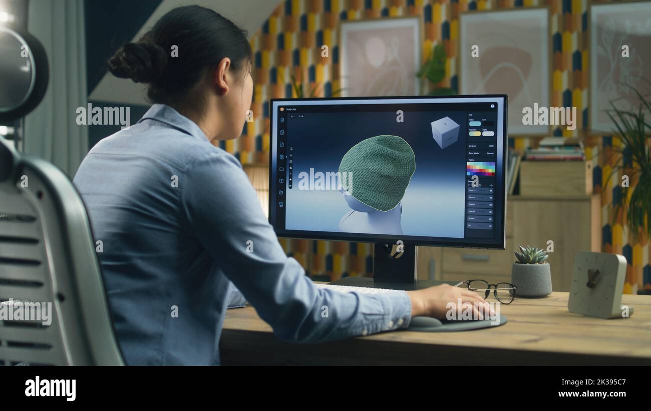 Female designer creating 3D visualization of clothes using computer and ...