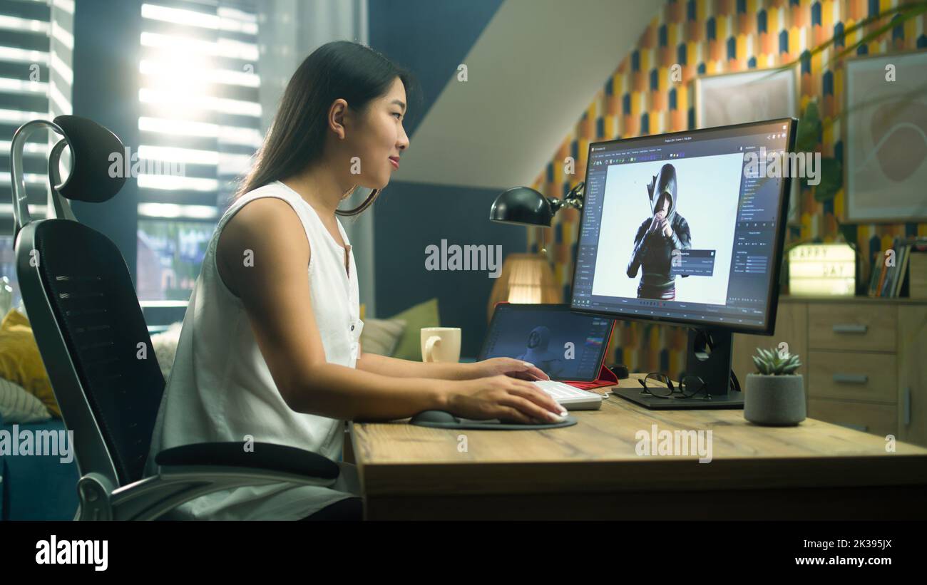 Asian woman creating 3D model of video game character in professional program using computer and ...