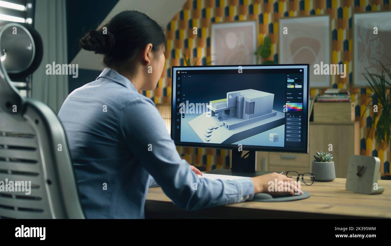 Female 3D designer at home working on 3D modeling project of house and creating exterior in ...