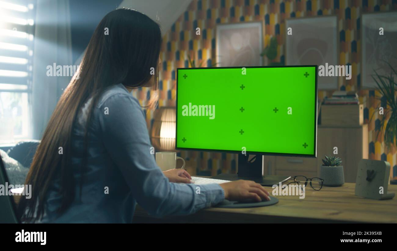 Asian woman sitting at the table and looking at screen of personal ...