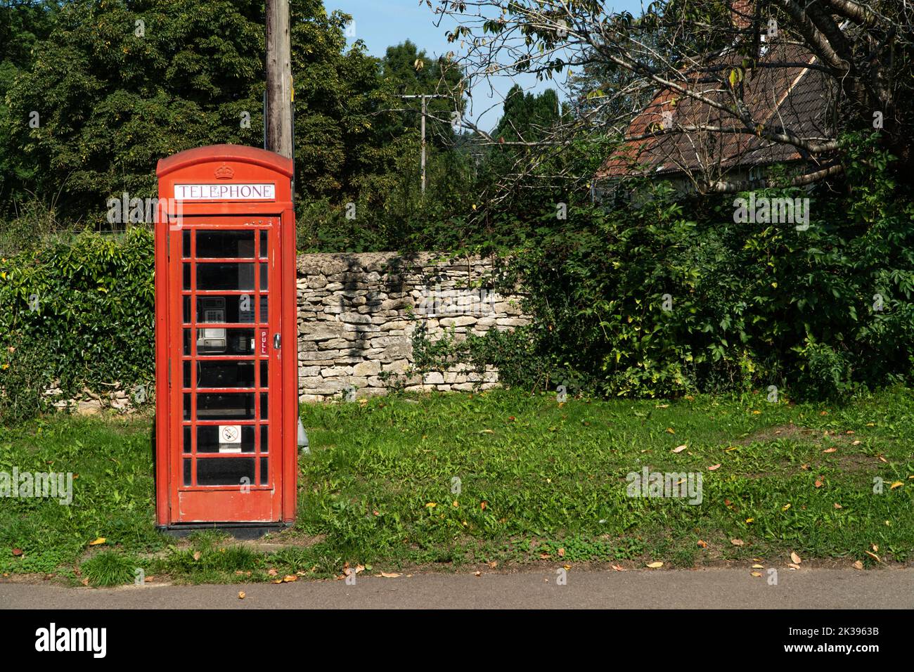 A traditional English red telephone box in village in Gloucestershire ...