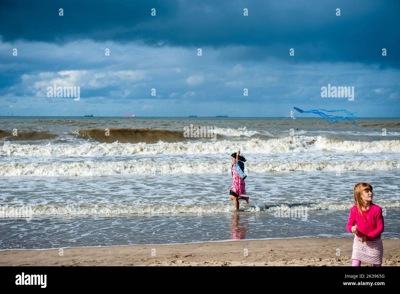 A woman is seen running along the shore while flying a small kite. The ...