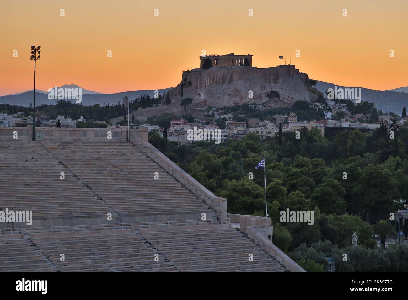 A scenic view of the Parthenon in the city of Athens, as the sun is setting in the background ...