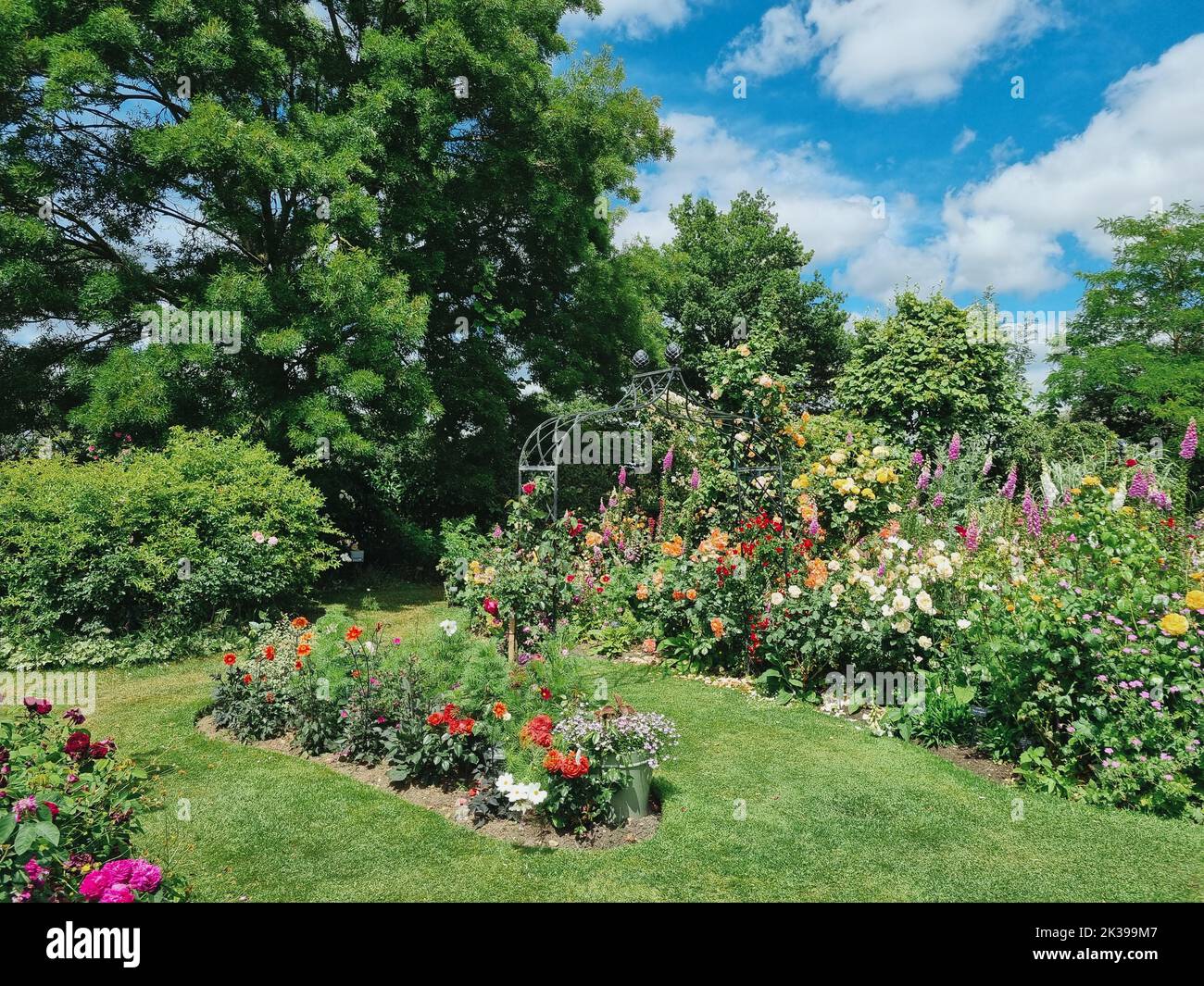 A scenic view of a botanical garden with greenery and flowers under a ...