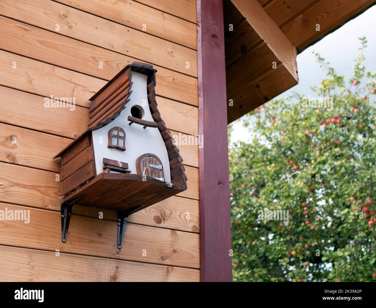 Hanging wooden bird house on the wall of a building, selective focus ...