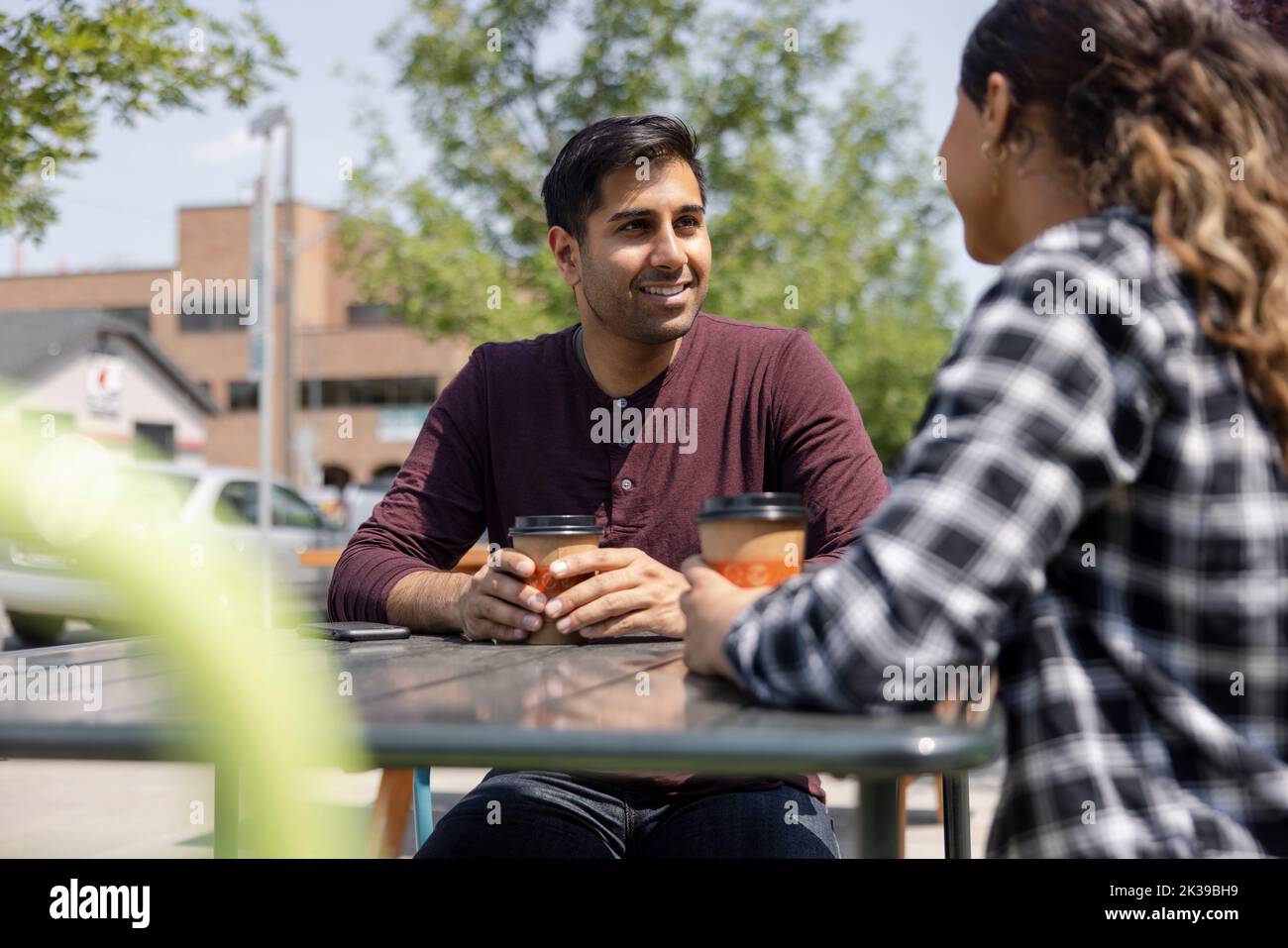 Cheerful man enjoying coffee with friend at cafe terrace Stock Photo ...