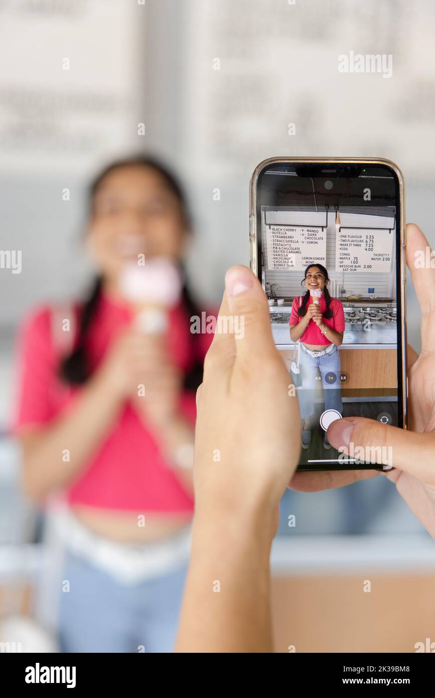 Close Up Of Phone Photographing Cheerful Girl Holding Ice Cream Cone