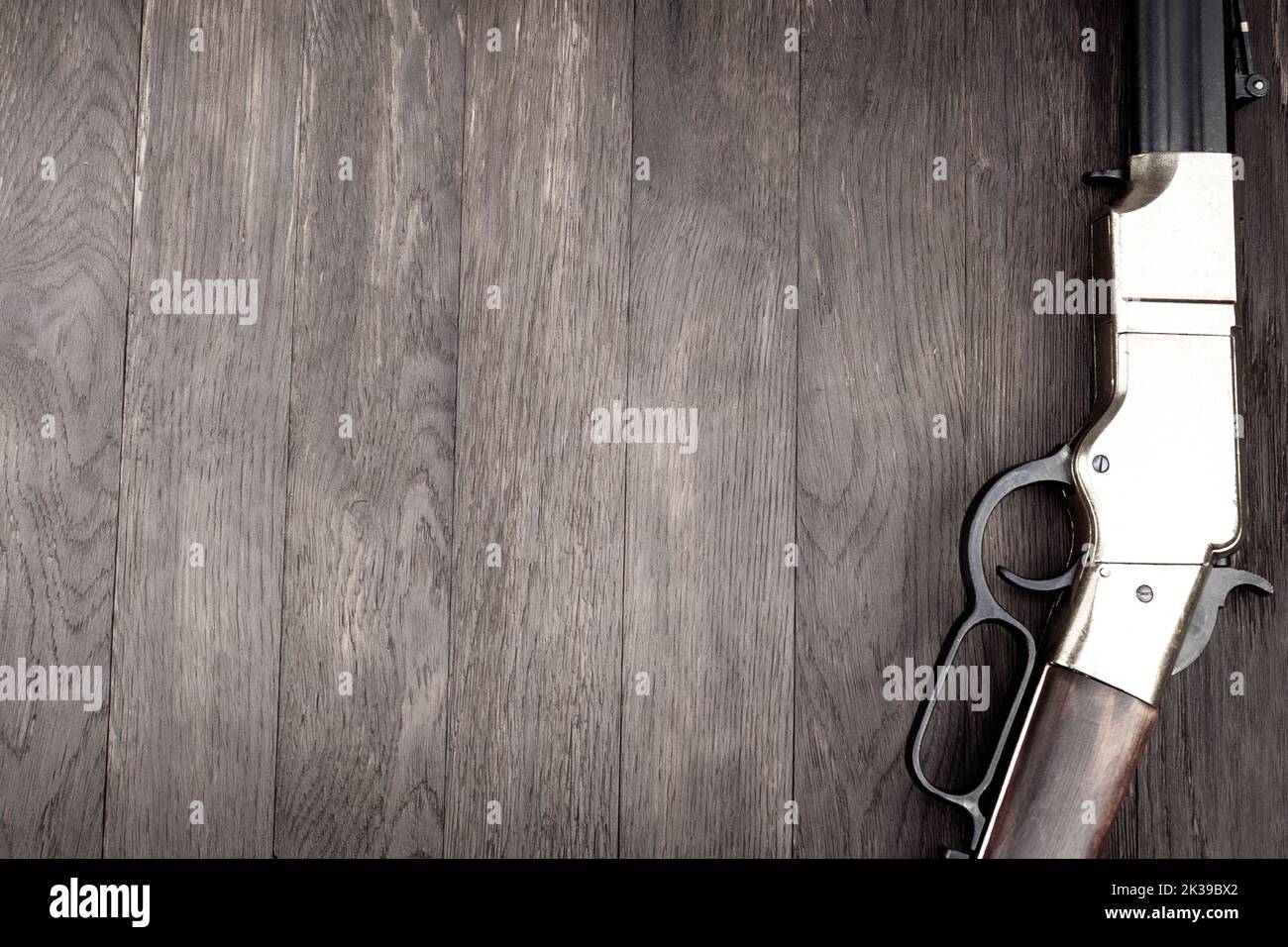 Old west gun - lever-action repeating rifle on wooden table Stock Photo ...