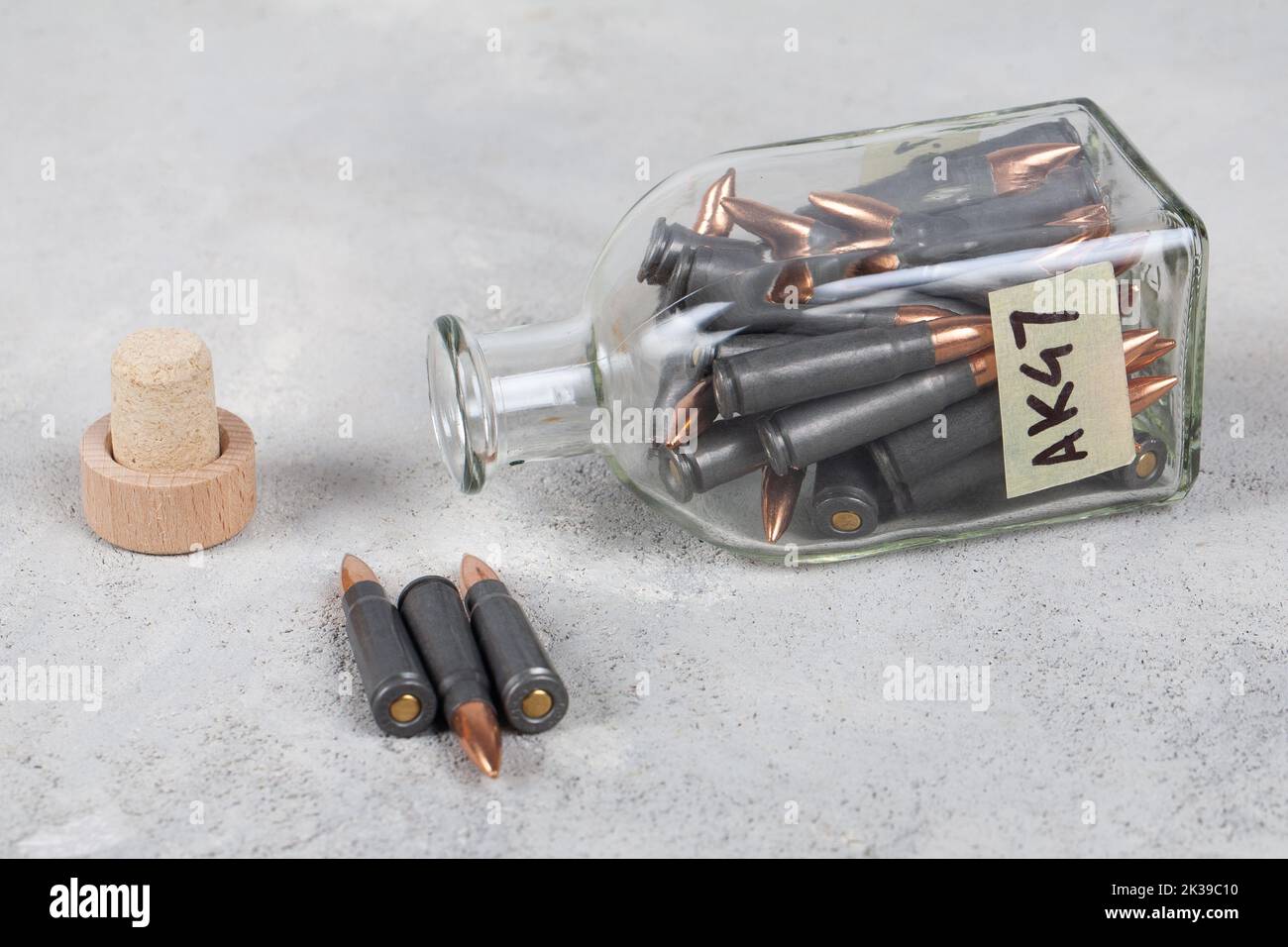 kalashnikov 7,62 mm bullets in a glass spice jar on grey concrete ...