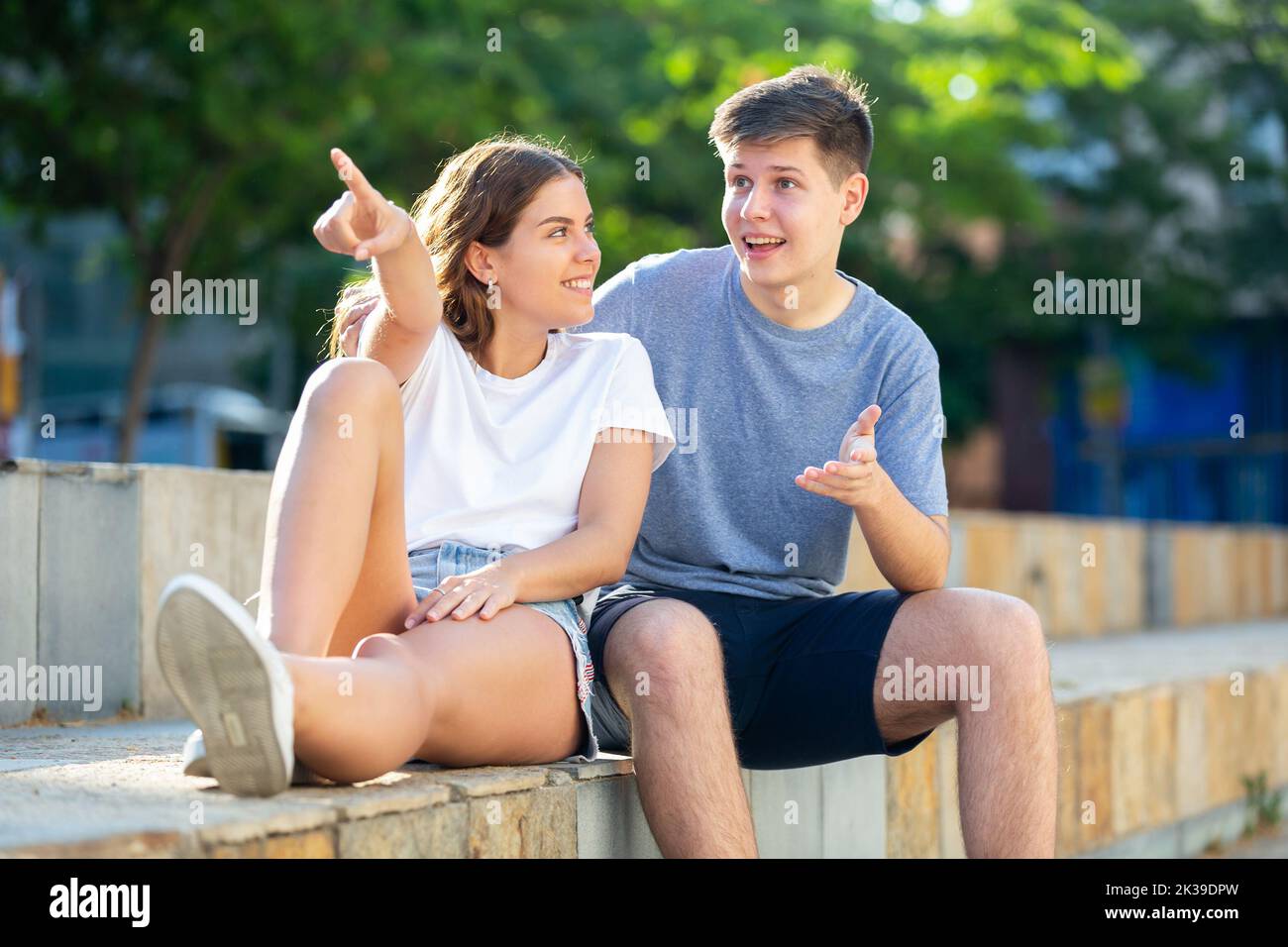 Girl prompts the boy, pointing with his hand at something Stock Photo ...