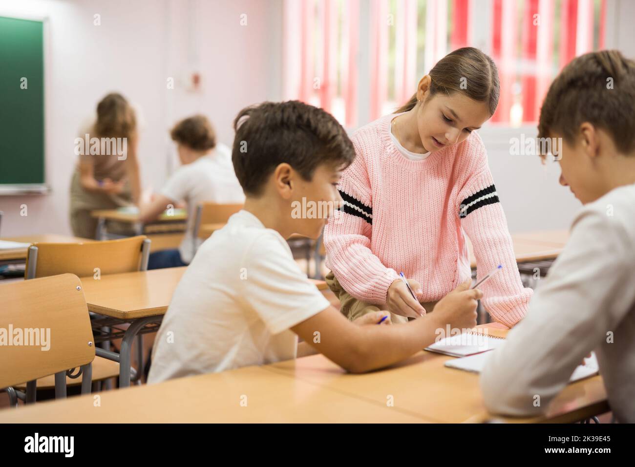 Fellow students having group work tasks during school class Stock Photo ...