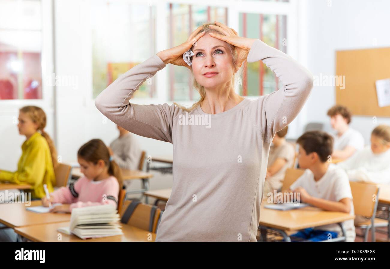 Portrait of frustrated tired teacher against the background of school ...