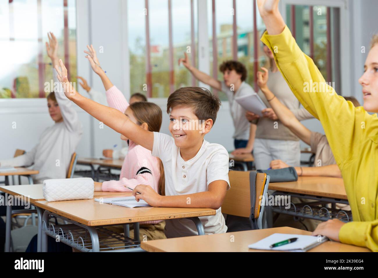Students raise their hand to answer during lesson in class Stock Photo ...