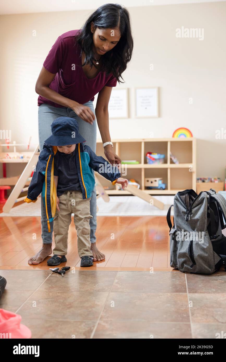 Boy putting on jacket hi-res stock photography and images - Alamy