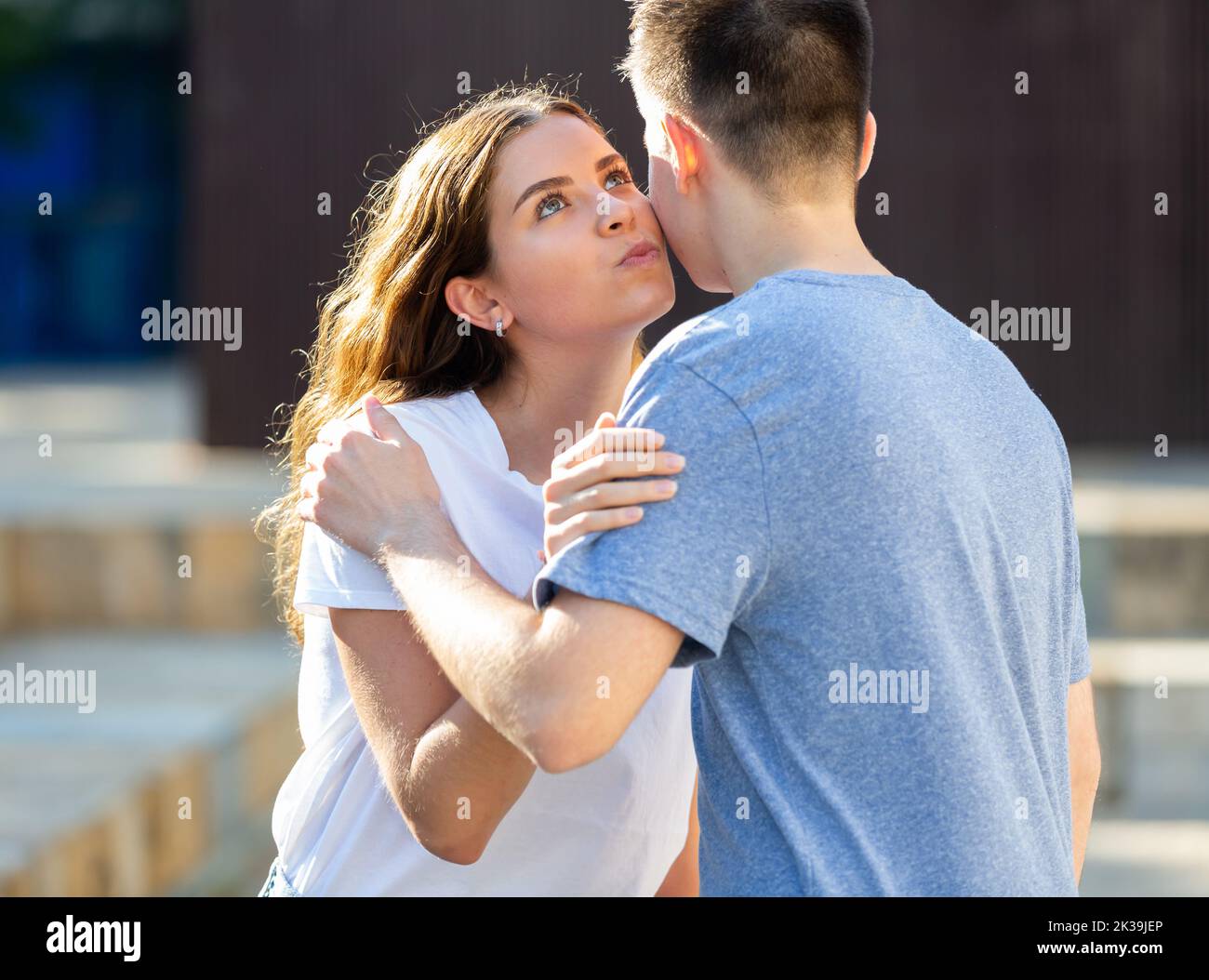 Kiss on cheek of boy and girl on street of summer city Stock Photo - Alamy