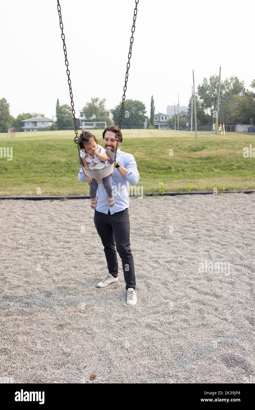 Pushing baby on swing hi-res stock photography and images - Alamy