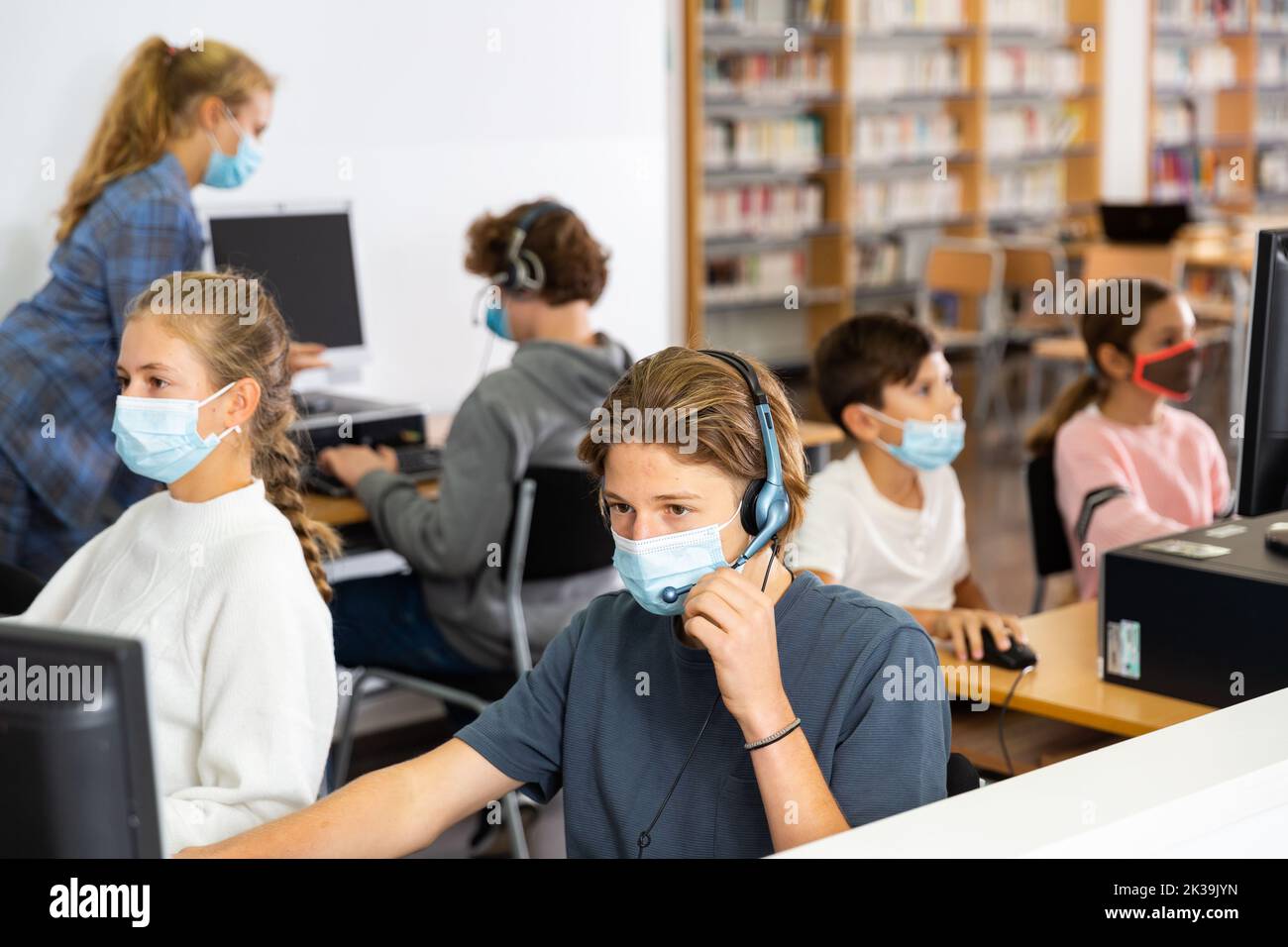 Teenagers wearing masks in computer class in library Stock Photo - Alamy