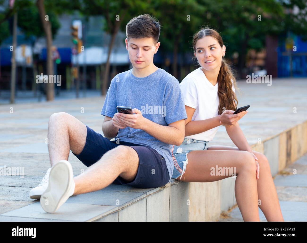 Two young people with mobile phones Stock Photo - Alamy