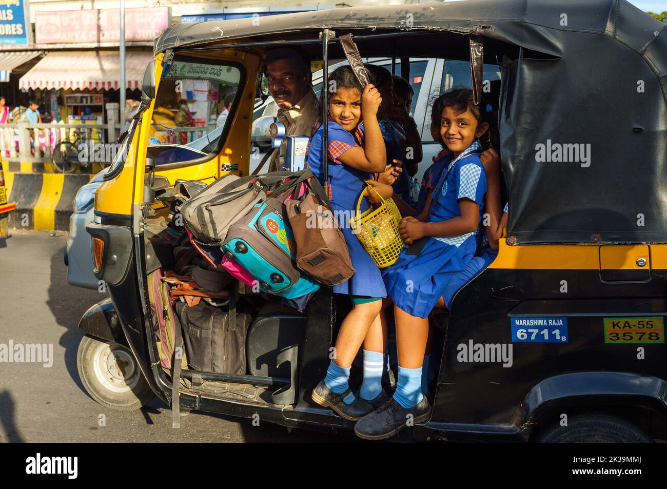 Young indian school girls riding in a tuk tuk with bags Stock Photo - Alamy