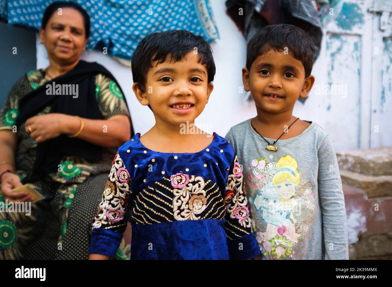 Young Indian children smiling in front of their mother Stock Photo - Alamy