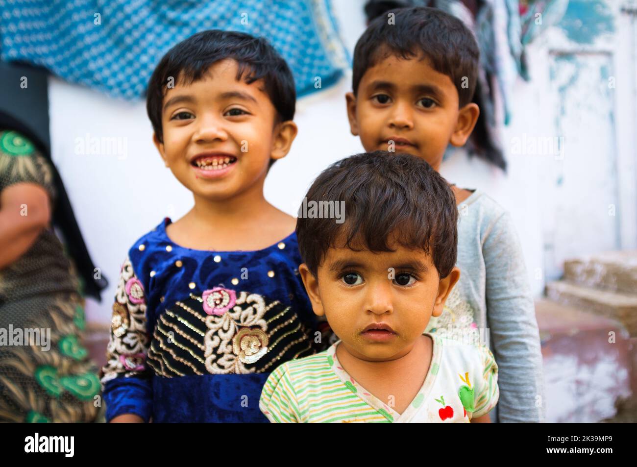 Young Indian children smiling in front of their mother Stock Photo - Alamy