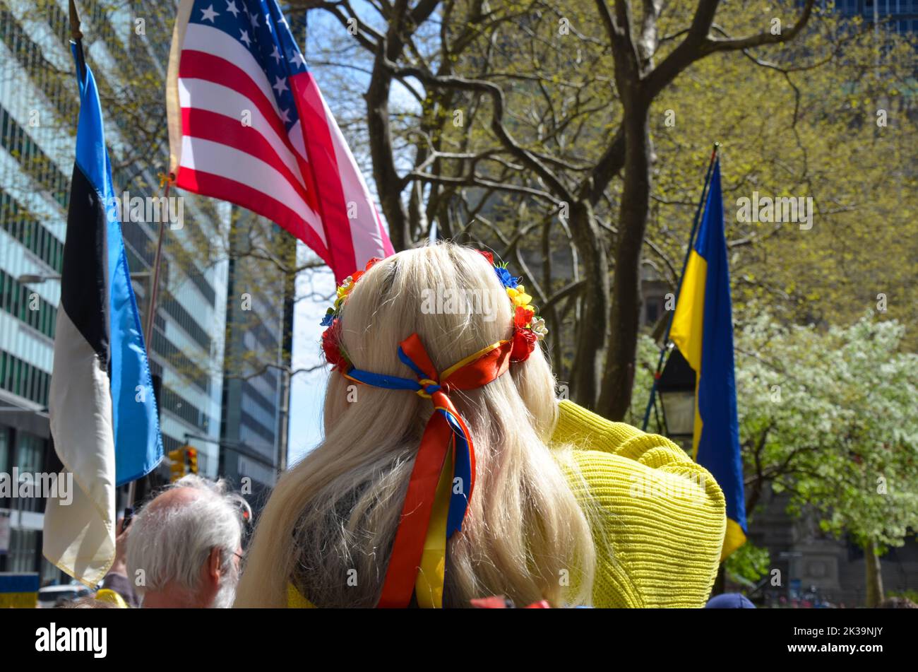 The back of a girl in a colorful head ribbon symbolizing Ukrainian flag ...