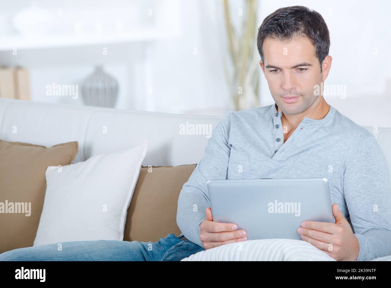 relaxed man at home using a digital tablet Stock Photo - Alamy