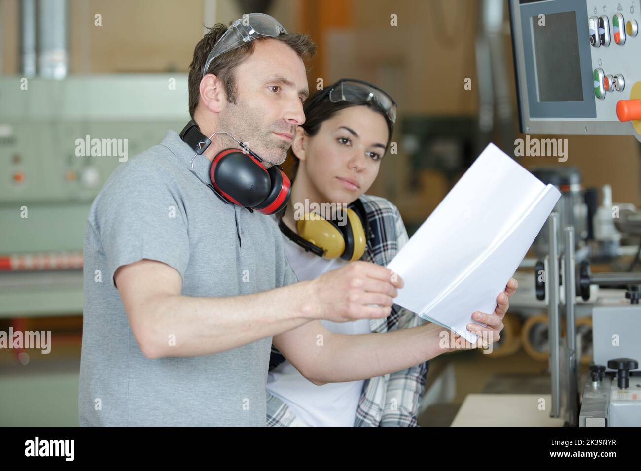 man and woman reading paperwork before using machine Stock Photo - Alamy