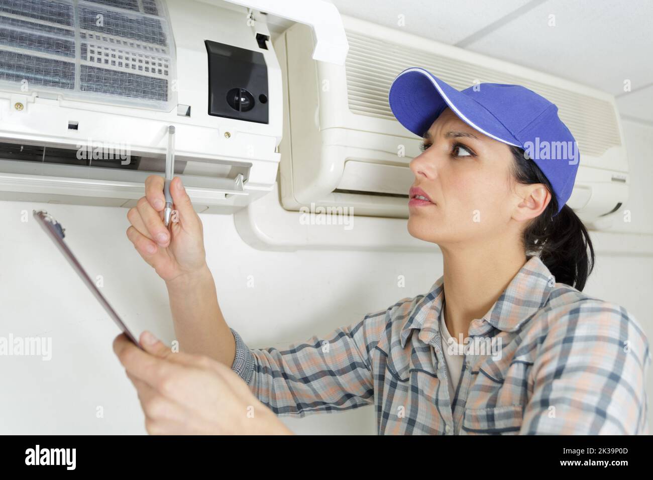 a young woman cleaning air conditioning system at home Stock Photo - Alamy